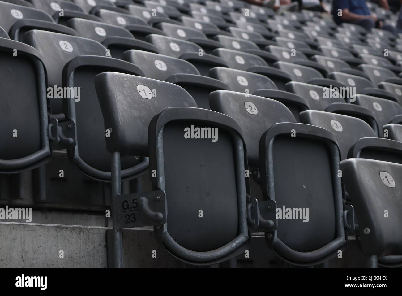 The empty rows of black chairs of a stadium, isolated on a blurred ...