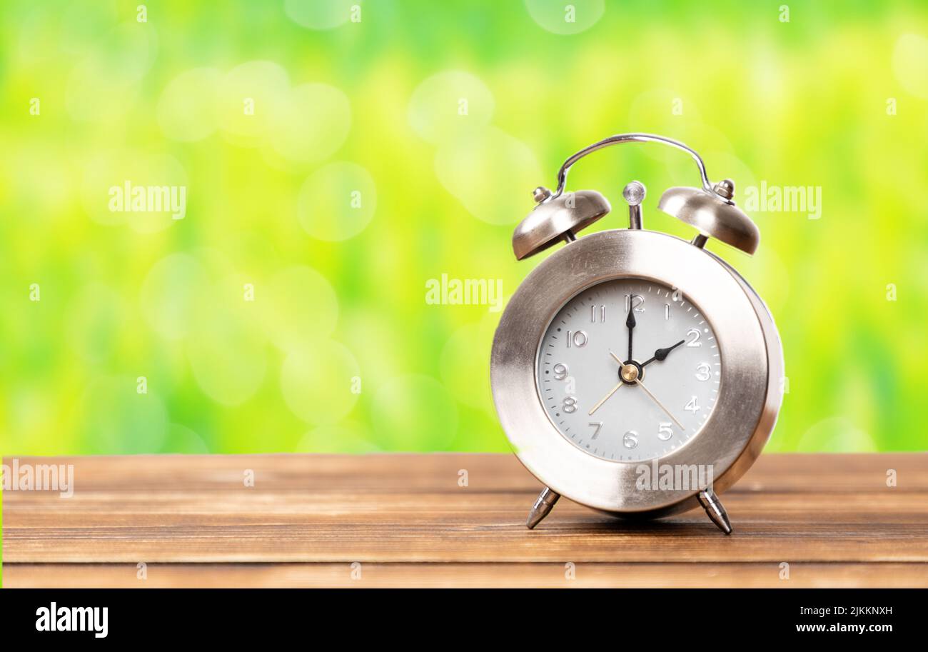 clock for summer time change with copy space with green garden ...