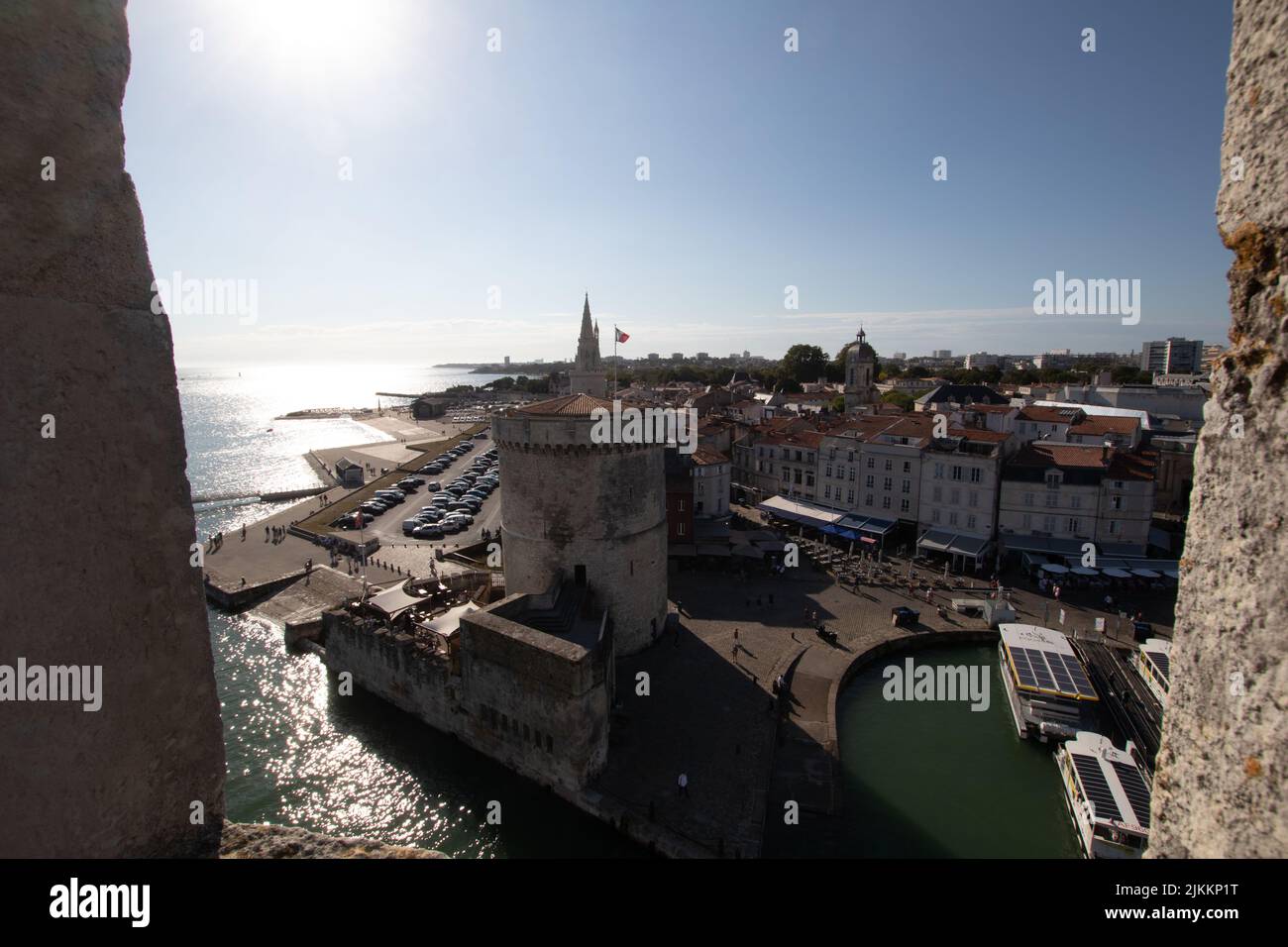 A view of La Rochelle tower from stony viewpoint under shining sun ...