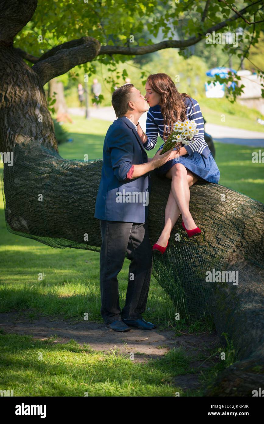 A vertical shot of a cute Latvian couple kissing in a park Stock Photo ...