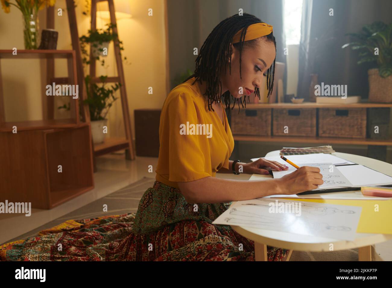Talented Black woman drawing sketches for new fashion collection Stock ...
