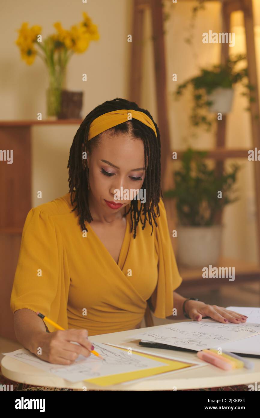 Creative Black woman drawing fashion sketches for project in her ...