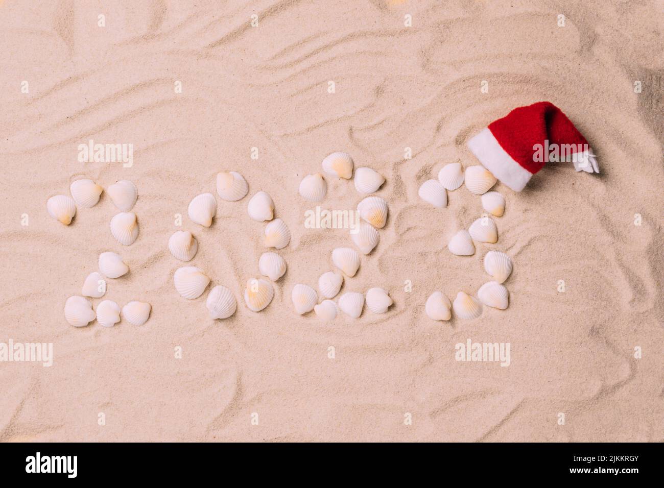 Symbolic numbers new year 2023 from sea shells and New Year's cap of ...