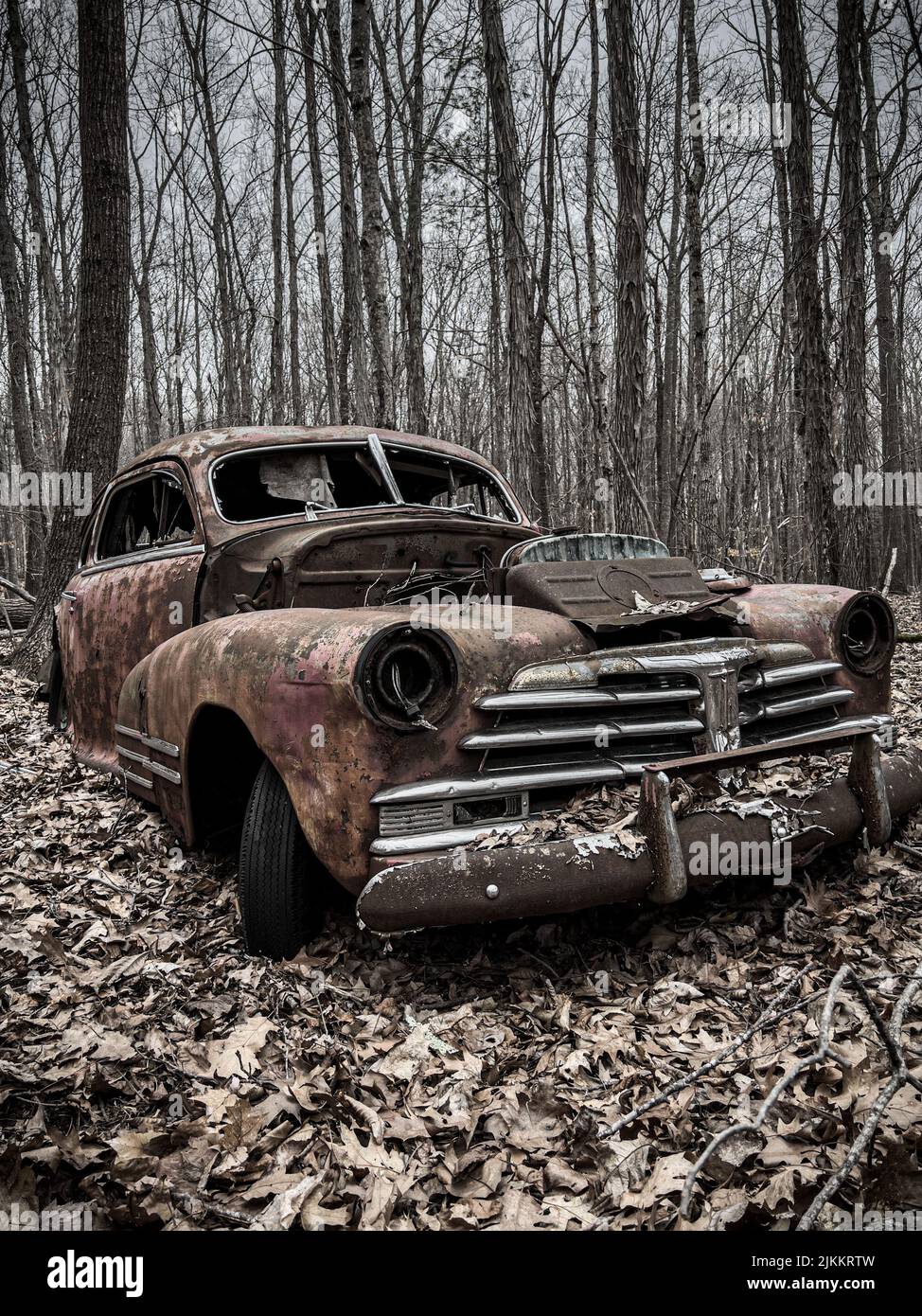 A vertical shot of an old broken abandoned car in a forest Stock Photo ...