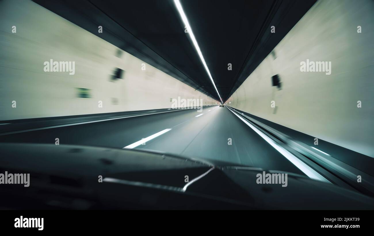 A View from the windshield of a car driving through a modern tunnel ...