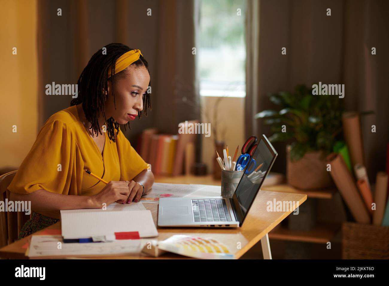Fashion designer reading e-mail with preferences of client on laptop ...