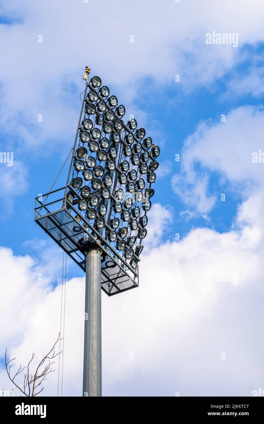 A huge pole of stadium light projectors against a sky Stock Photo - Alamy