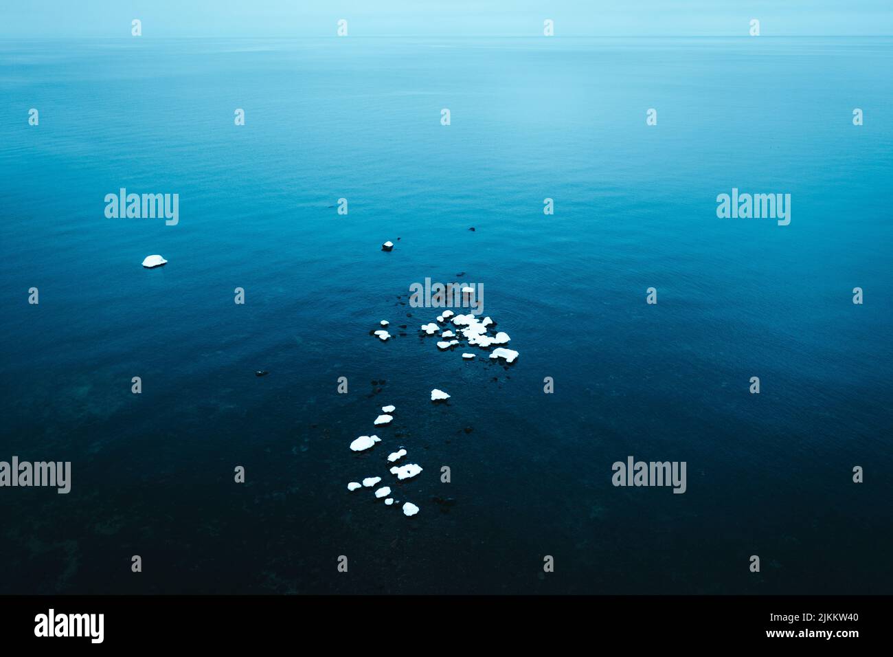 A chunks of ice on a calm blue sea Stock Photo - Alamy