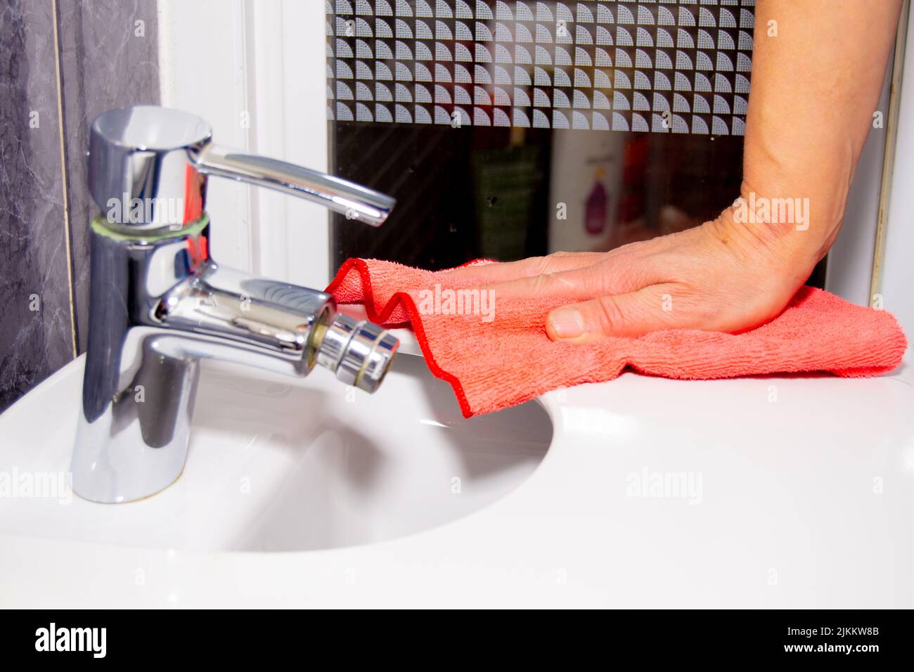 Hand cleaning a bath sink with a red rag Stock Photo - Alamy