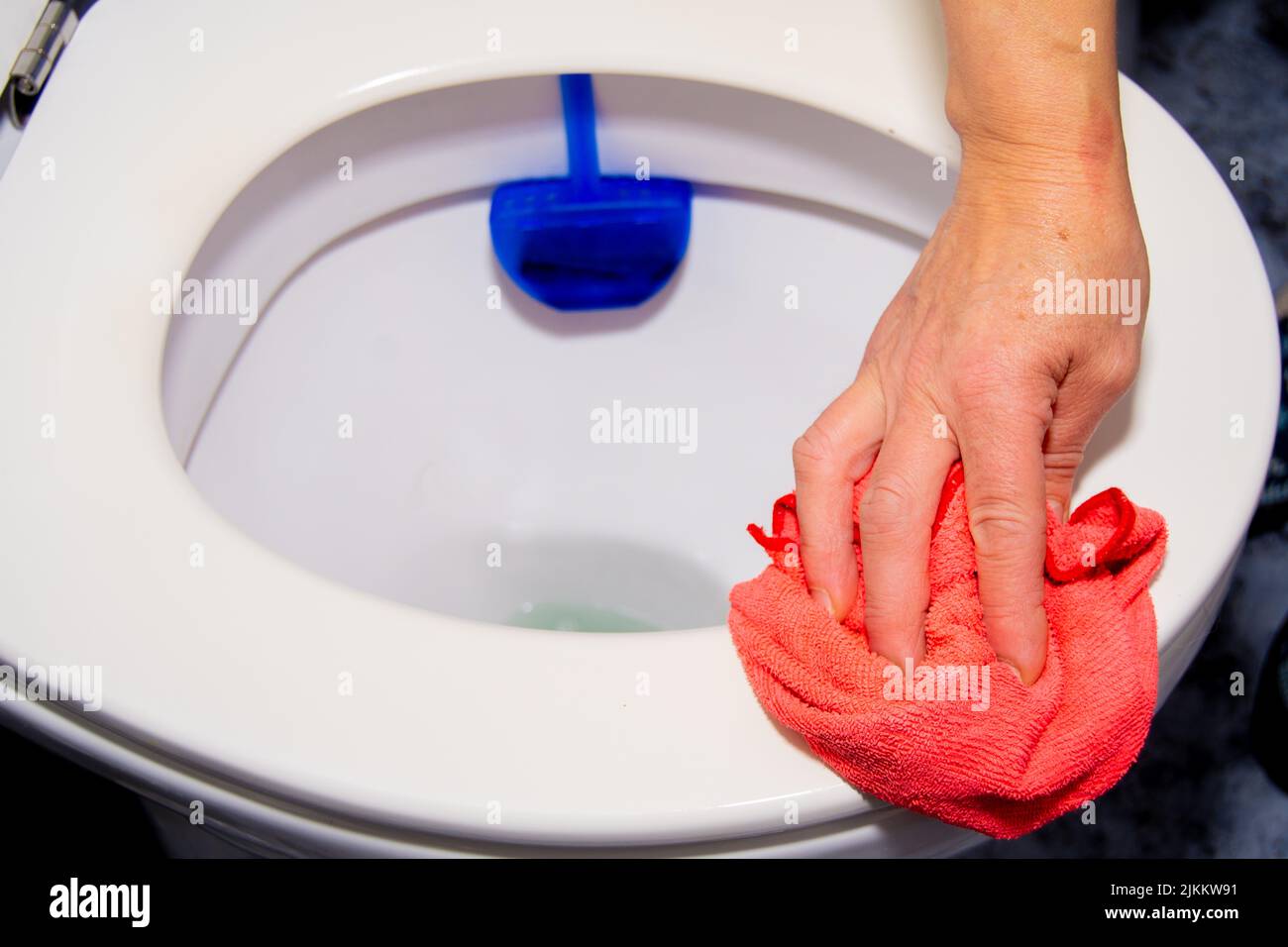 Hand cleaning a toilet with a red rag Stock Photo - Alamy