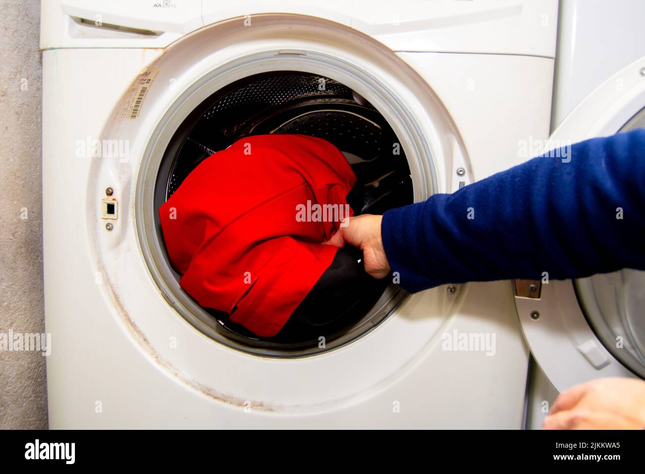 A hand of a woman doing laundry in a washer Stock Photo - Alamy
