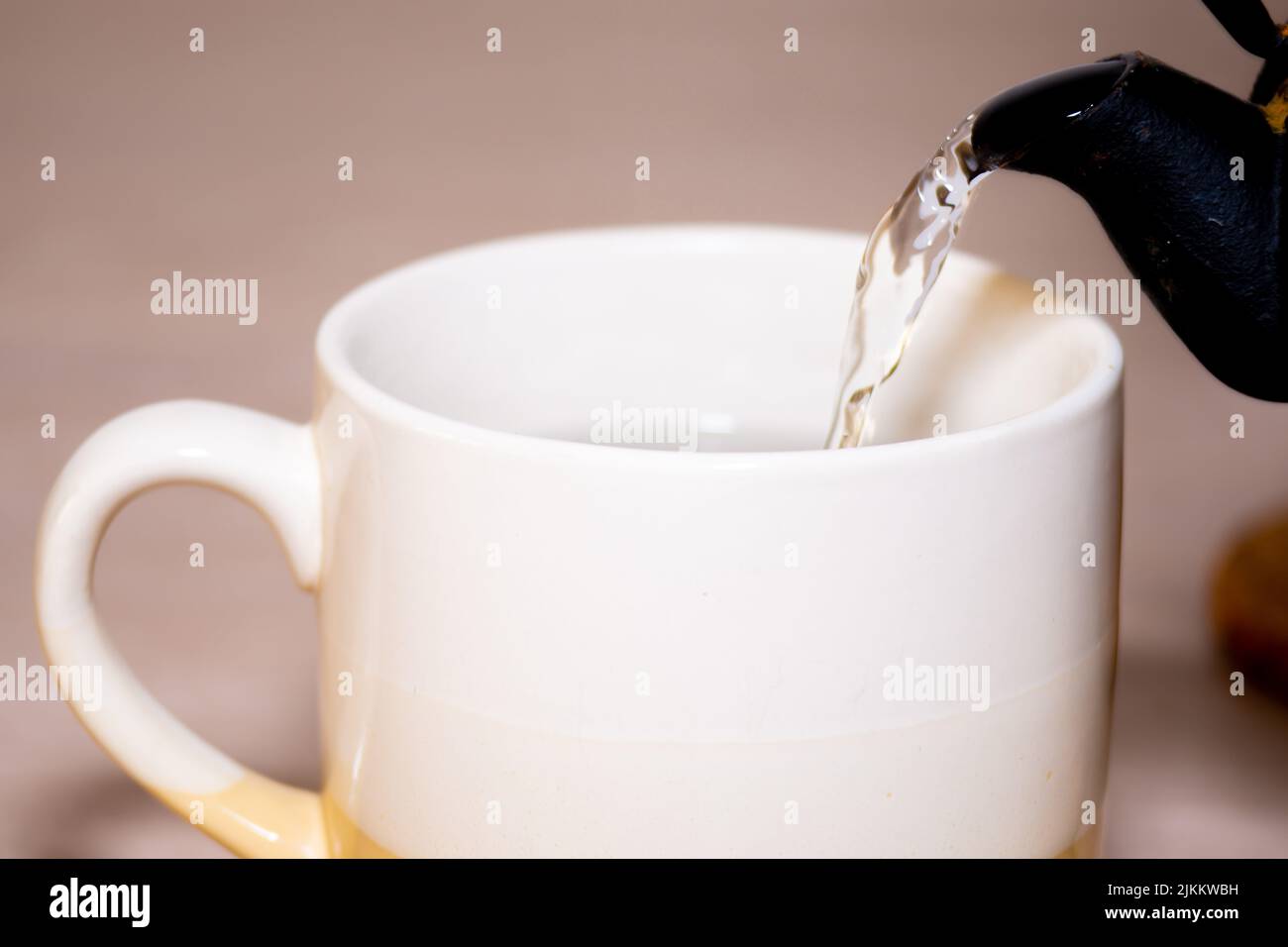 Filling cup of water for a tea with a kettl Stock Photo - Alamy