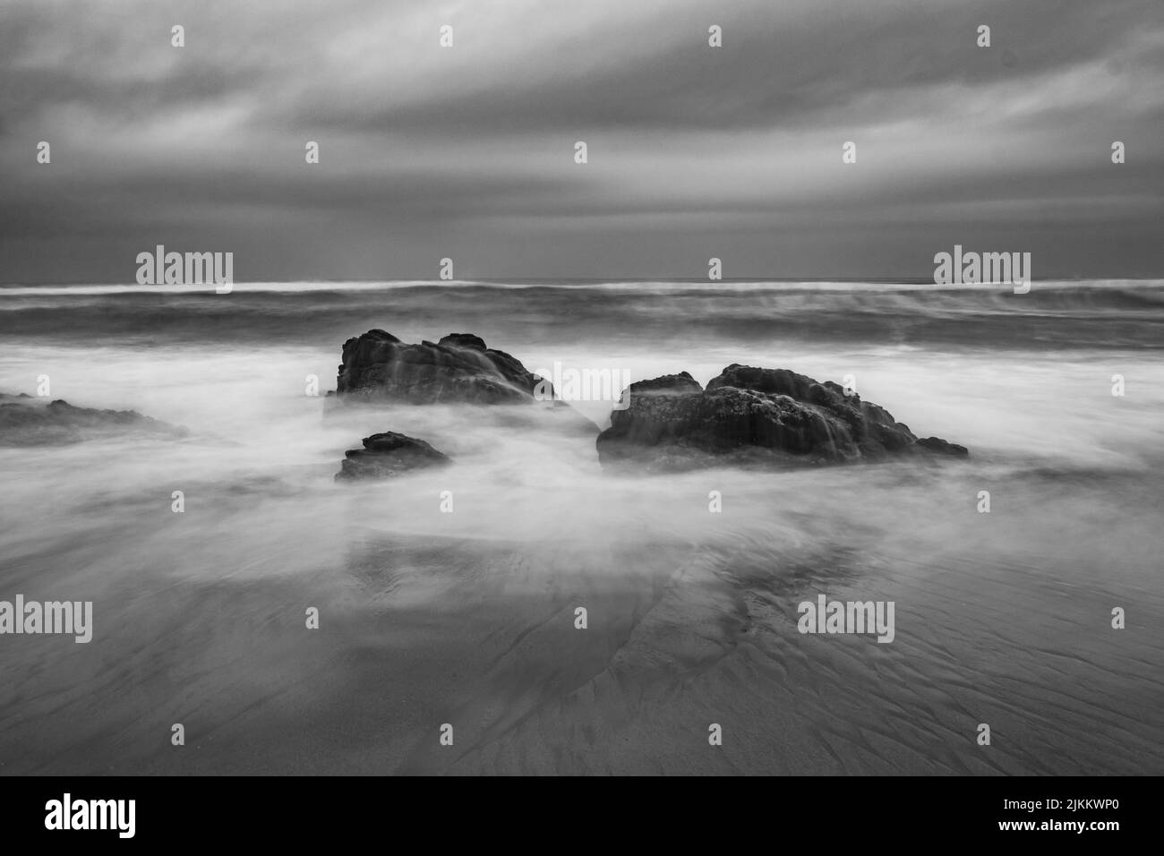 A grayscale shot of the rocky beach with long exposure Stock Photo - Alamy
