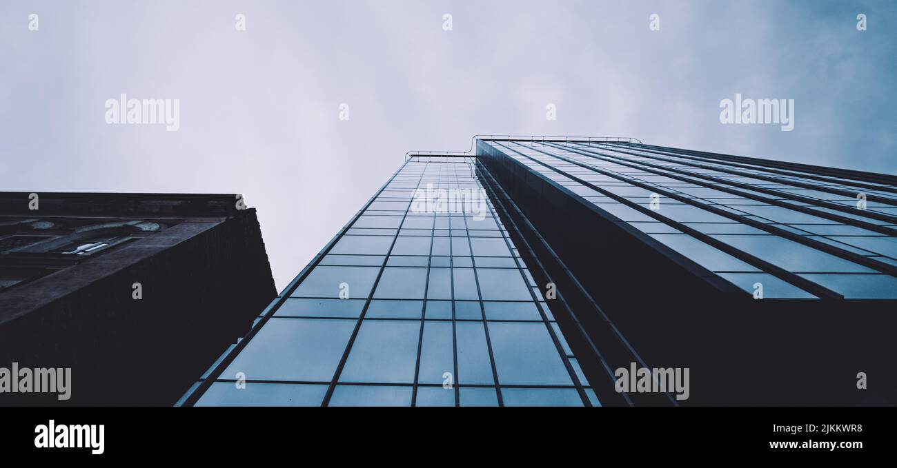 A low-angle shot of a blue glass facade of a high-rise building ...