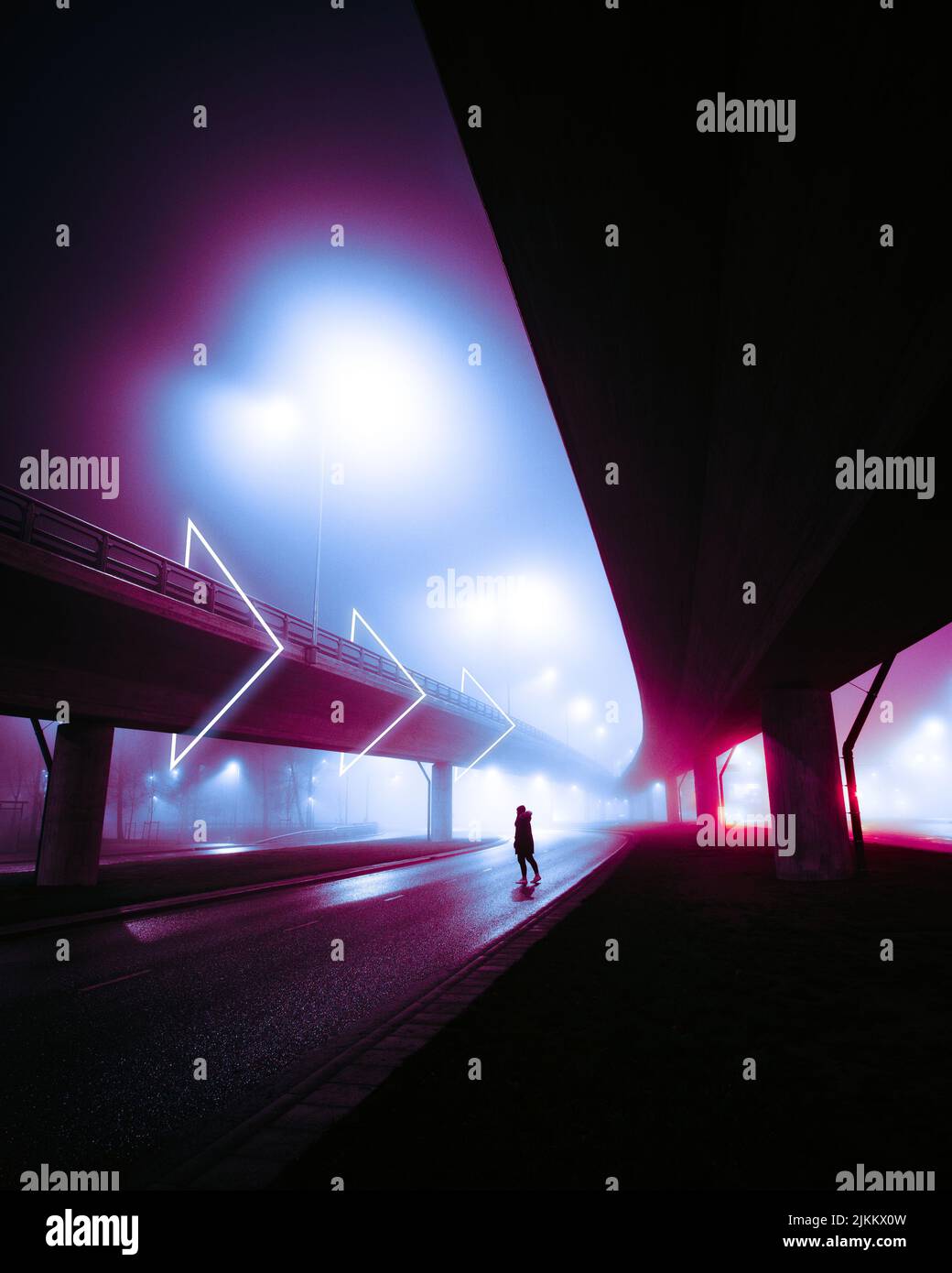 A view of a person standing in the middle of a road under overpass ...
