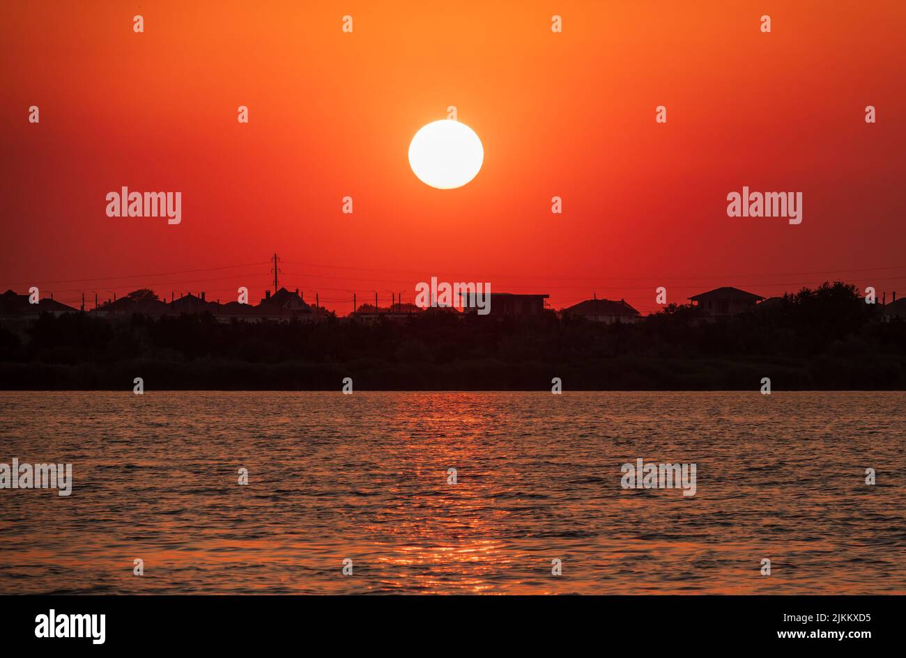 The sun goes down over a lake. Dramatic Sunset Sky Stock Photo - Alamy