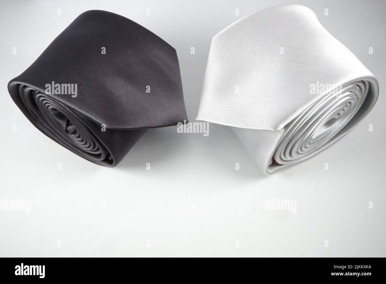 A closeup shot of rolled black and white polyester neckties isolated on ...