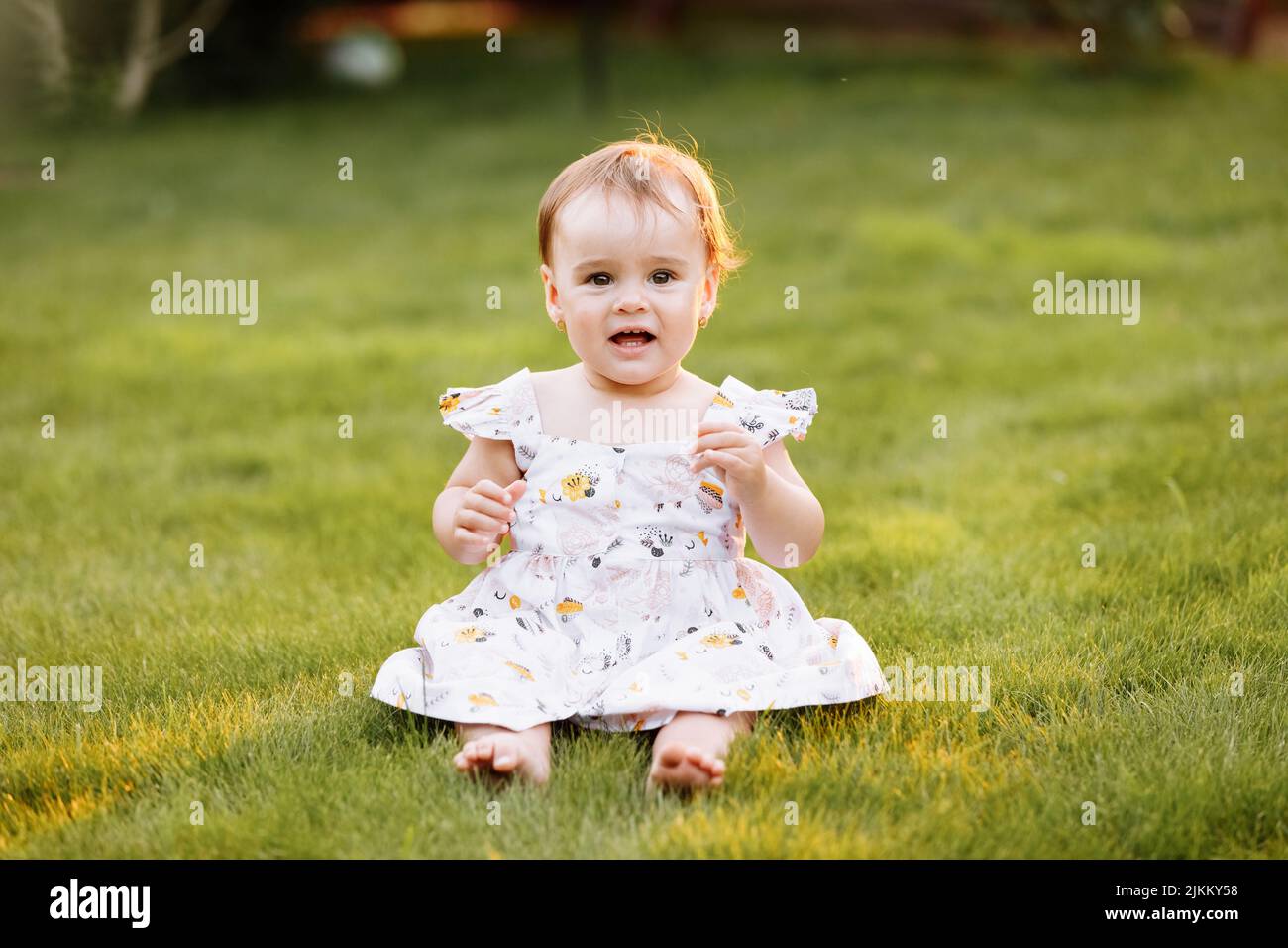 crying baby toddler girl on grass outdoors. Child feelings and emotions ...