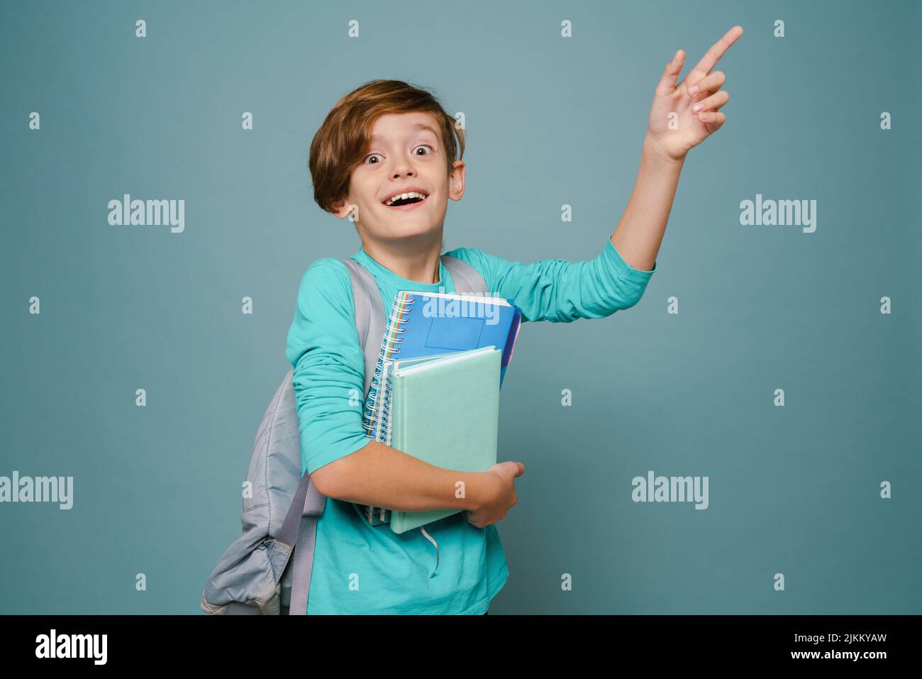 Ginger white boy gesturing while posing with exercise books isolated ...