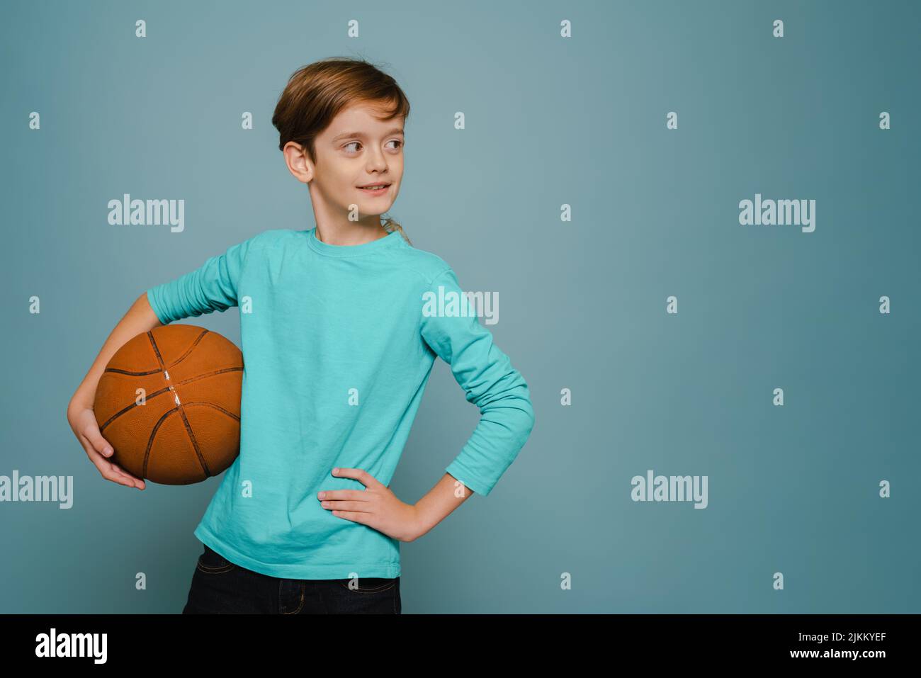 Ginger white boy smiling while posing with basketball isolated over ...