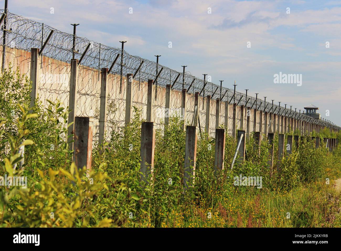 A large stone wall with barbed wire on the grounds of a Soviet Russian Prison Stock Photo - Alamy