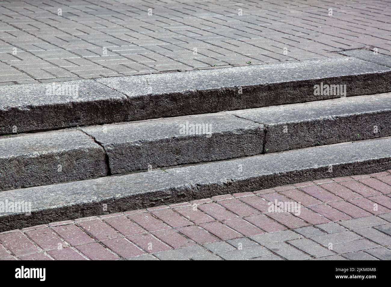 Gray granite steps in the middle of stone tile street pavement brick ...