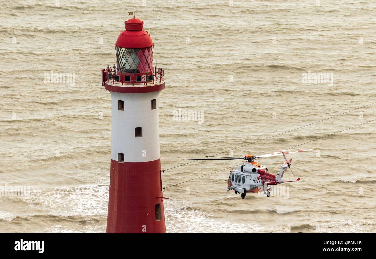 Coastguard helicopter hovering near lighthouse below the cliffs at ...