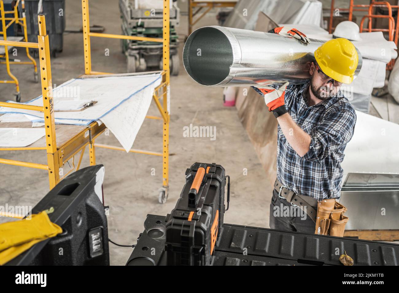 Caucasian Construction HVAC Worker in His 30s Unloading Pieces of Metal ...