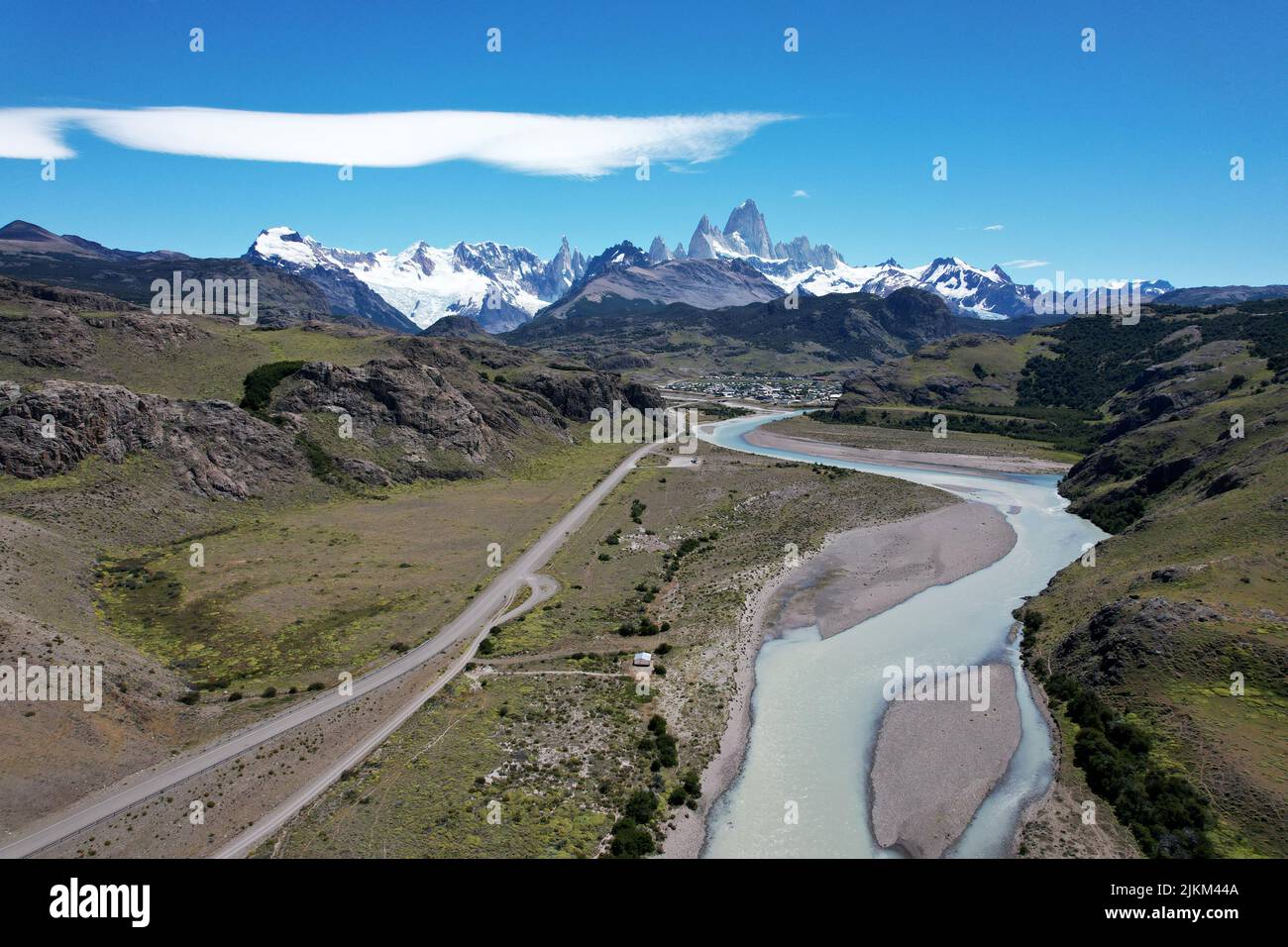 An aerial shot of a river next to a road and wild landscape in the ...