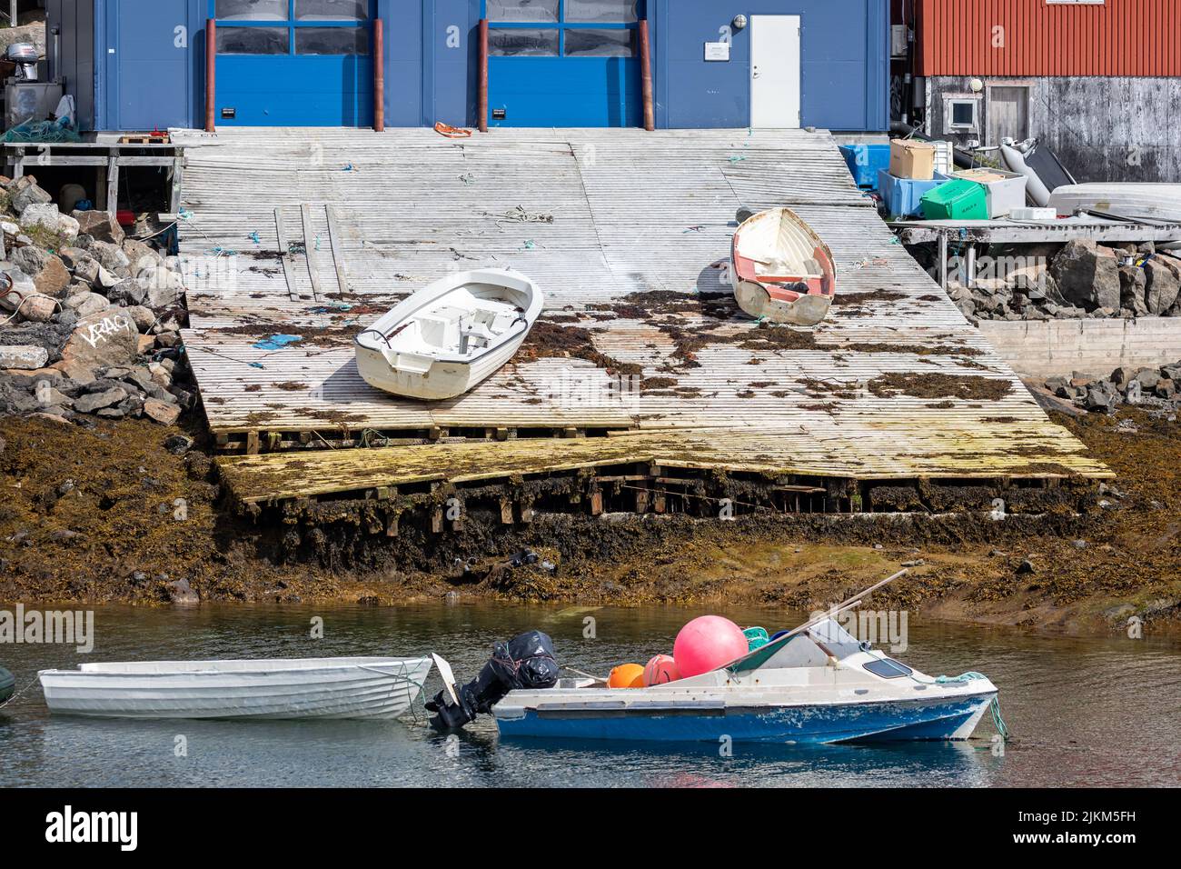 Fishing boats moored on dilapidated wooden pier in Maniitsoq, Greenland ...