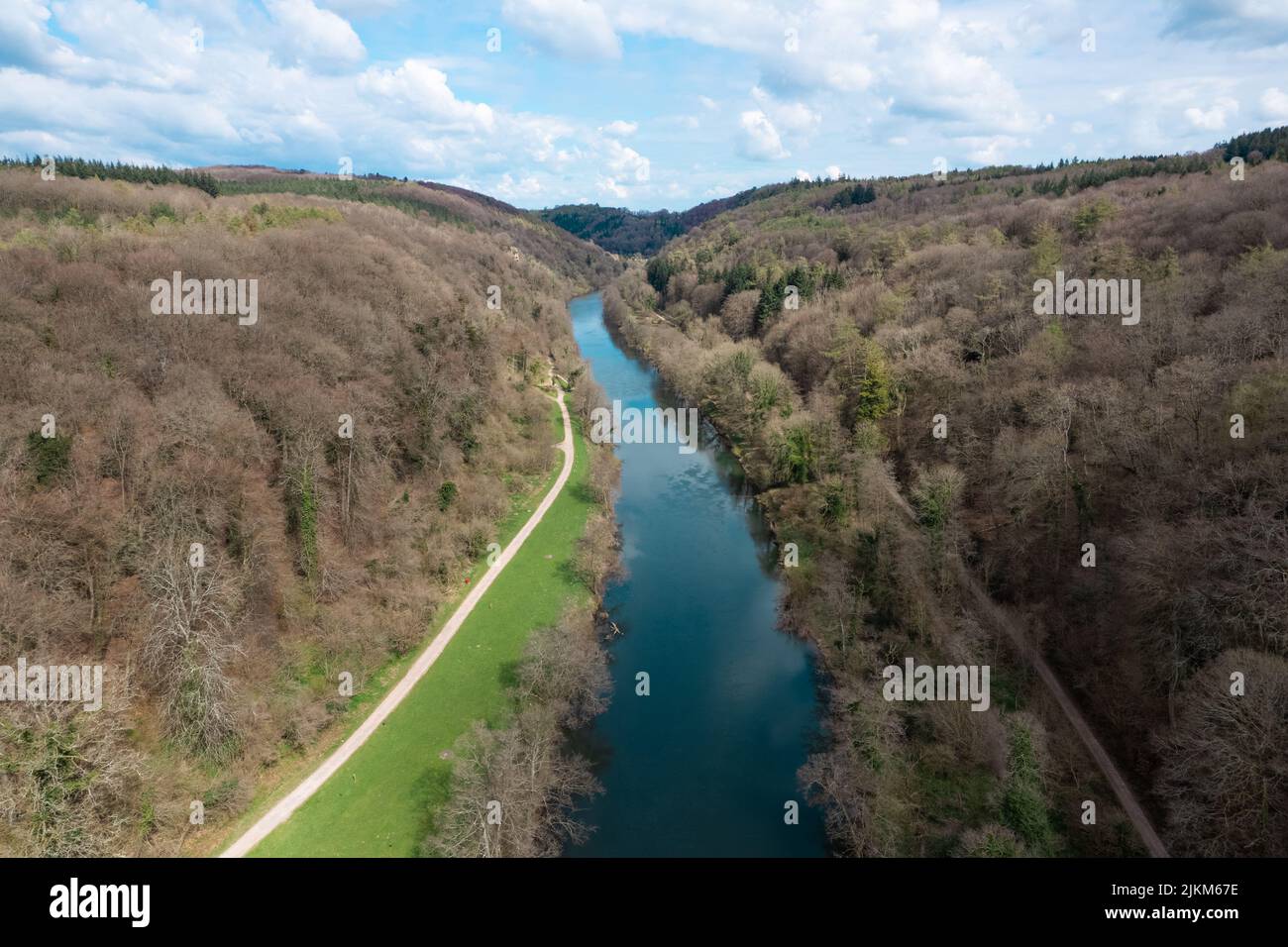 An aerial view of a blue river flowing down through forests under a ...