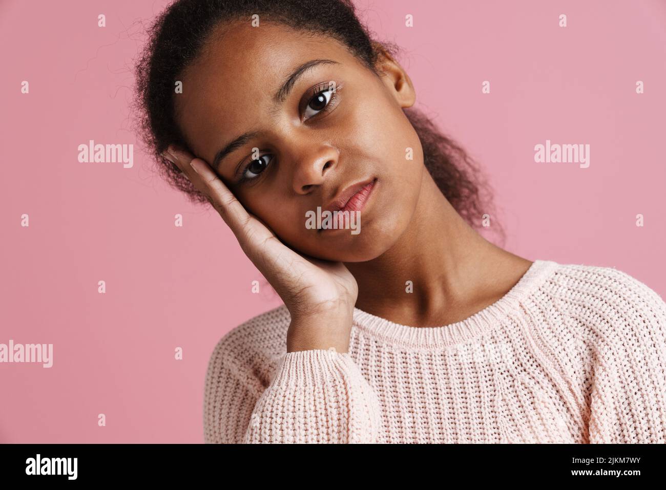 Brunette black girl propping up while looking at camera isolated over ...