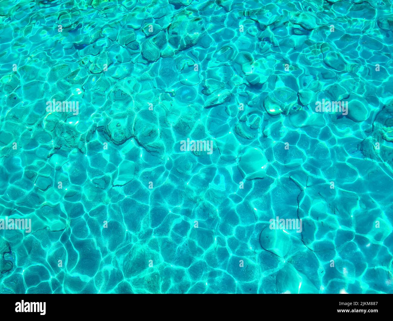 Turquoise surface of transparent sea water with sun glints Stock Photo ...