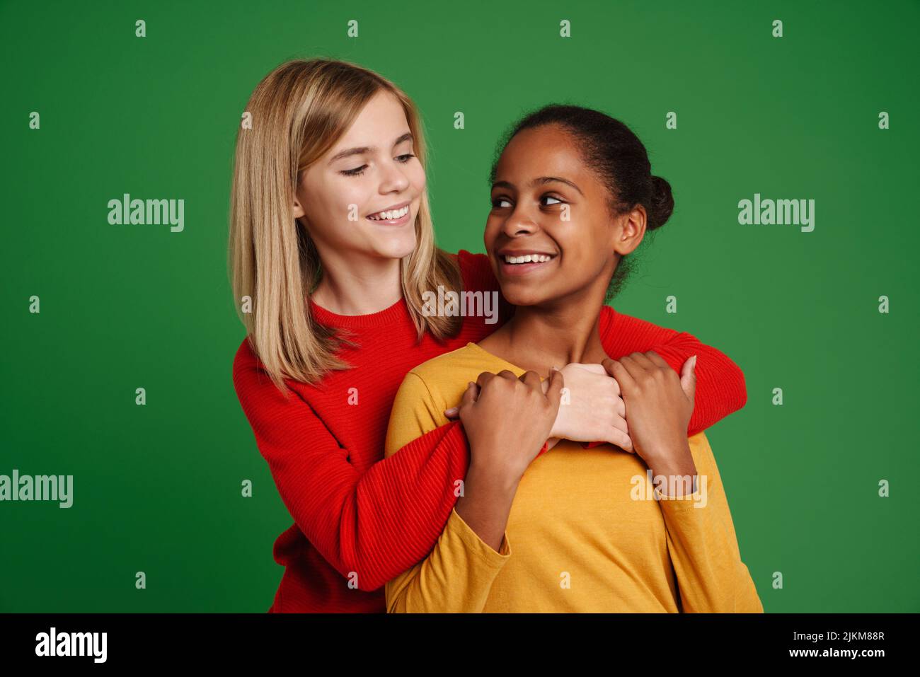 Multiracial Two Girls Smiling While Hugging Together Isolated Over