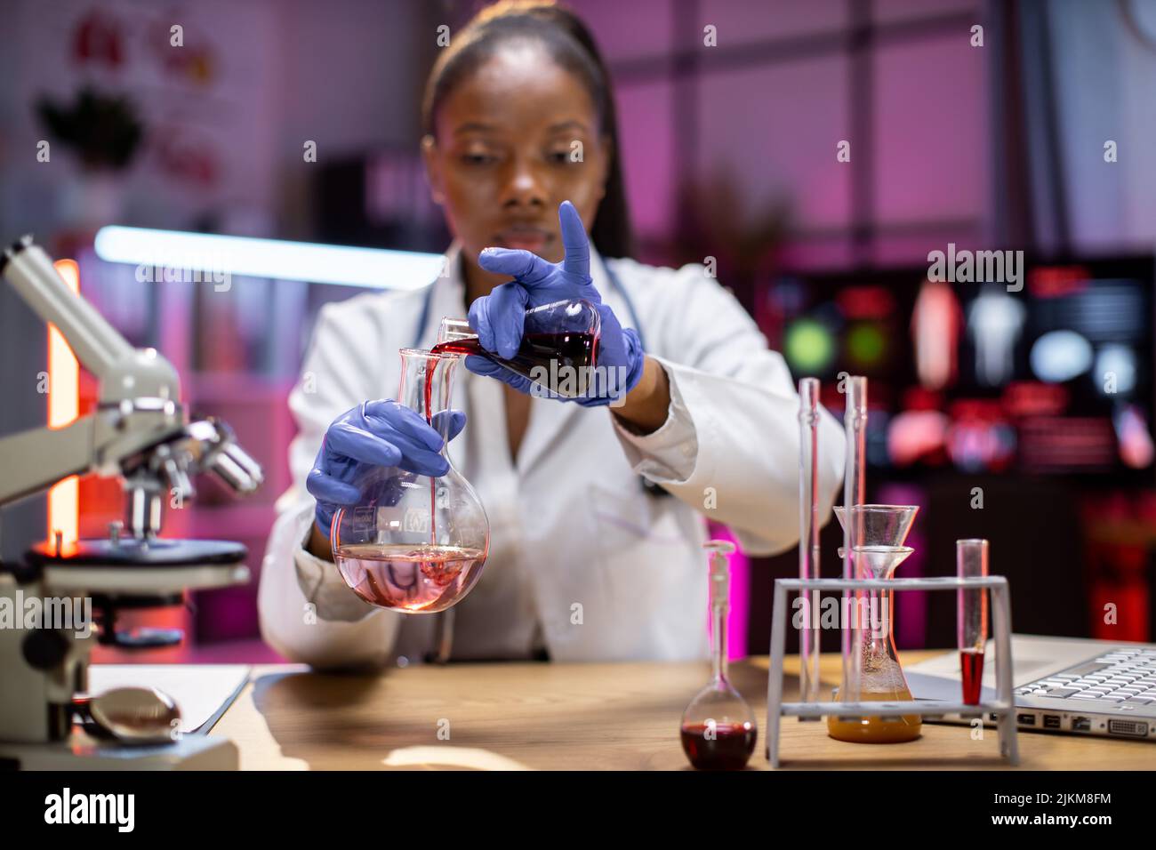 Female scientist testing experiment in a science lab where she holding ...