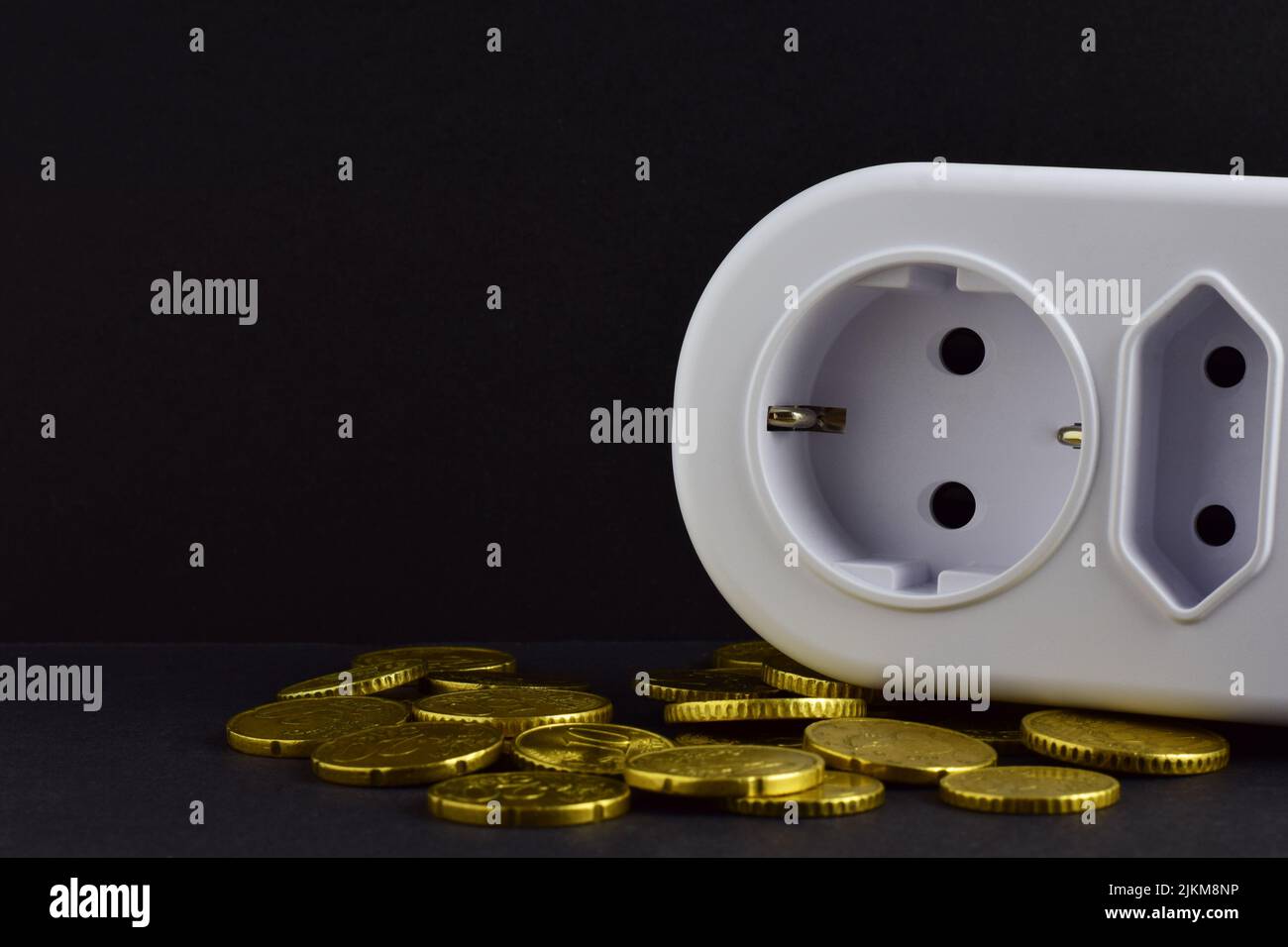 The golden coins and a plug isolated on a black background Stock Photo ...