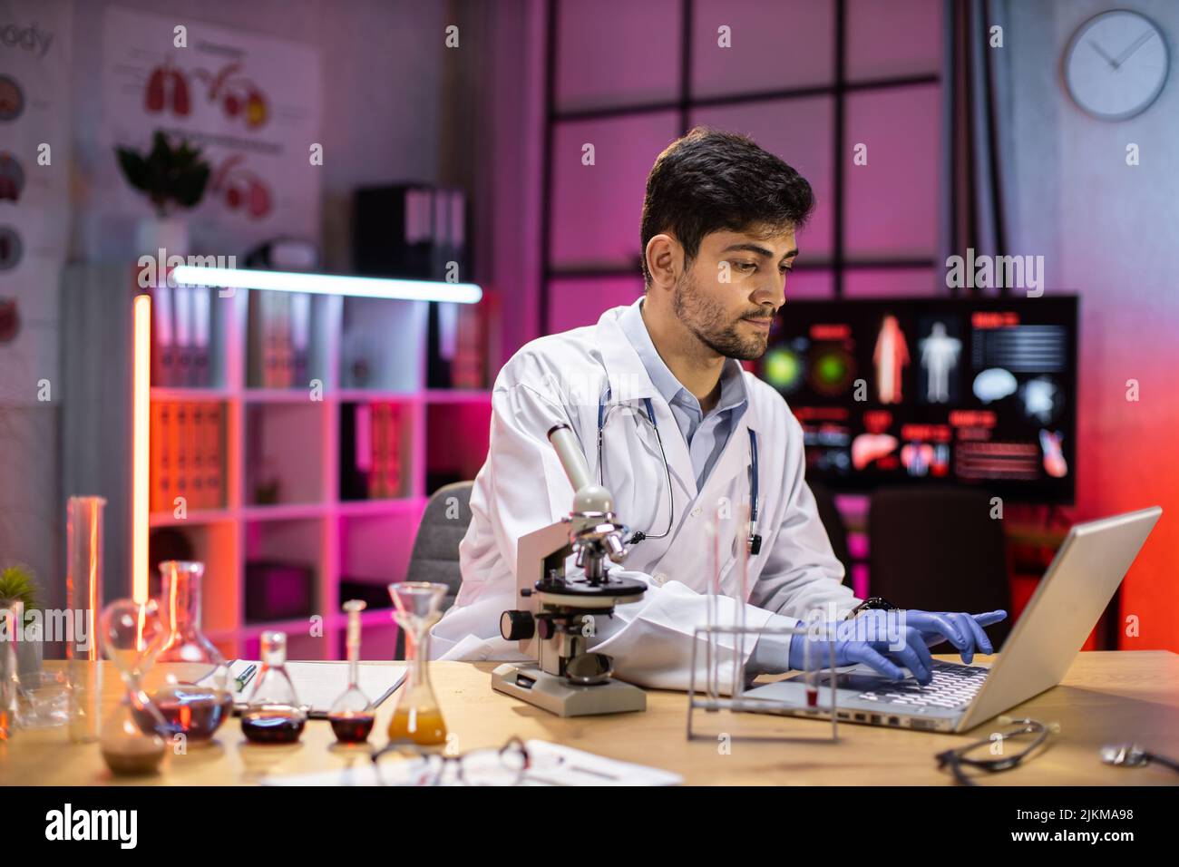 Medical research laboratory: portrait of a attractive male scientist using digital laptop ...
