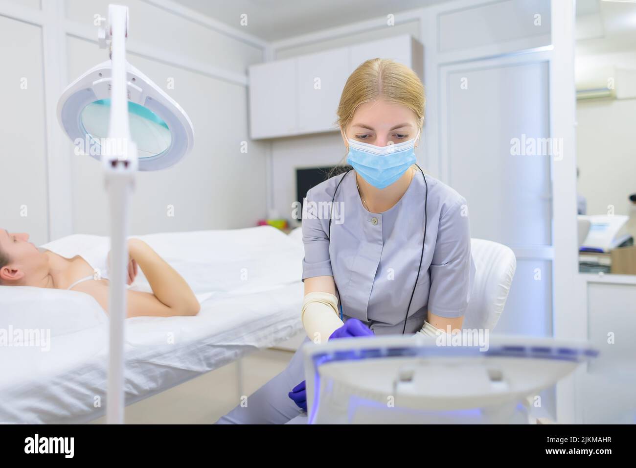 The electroepilation master sits at the workplace and sets up the ...