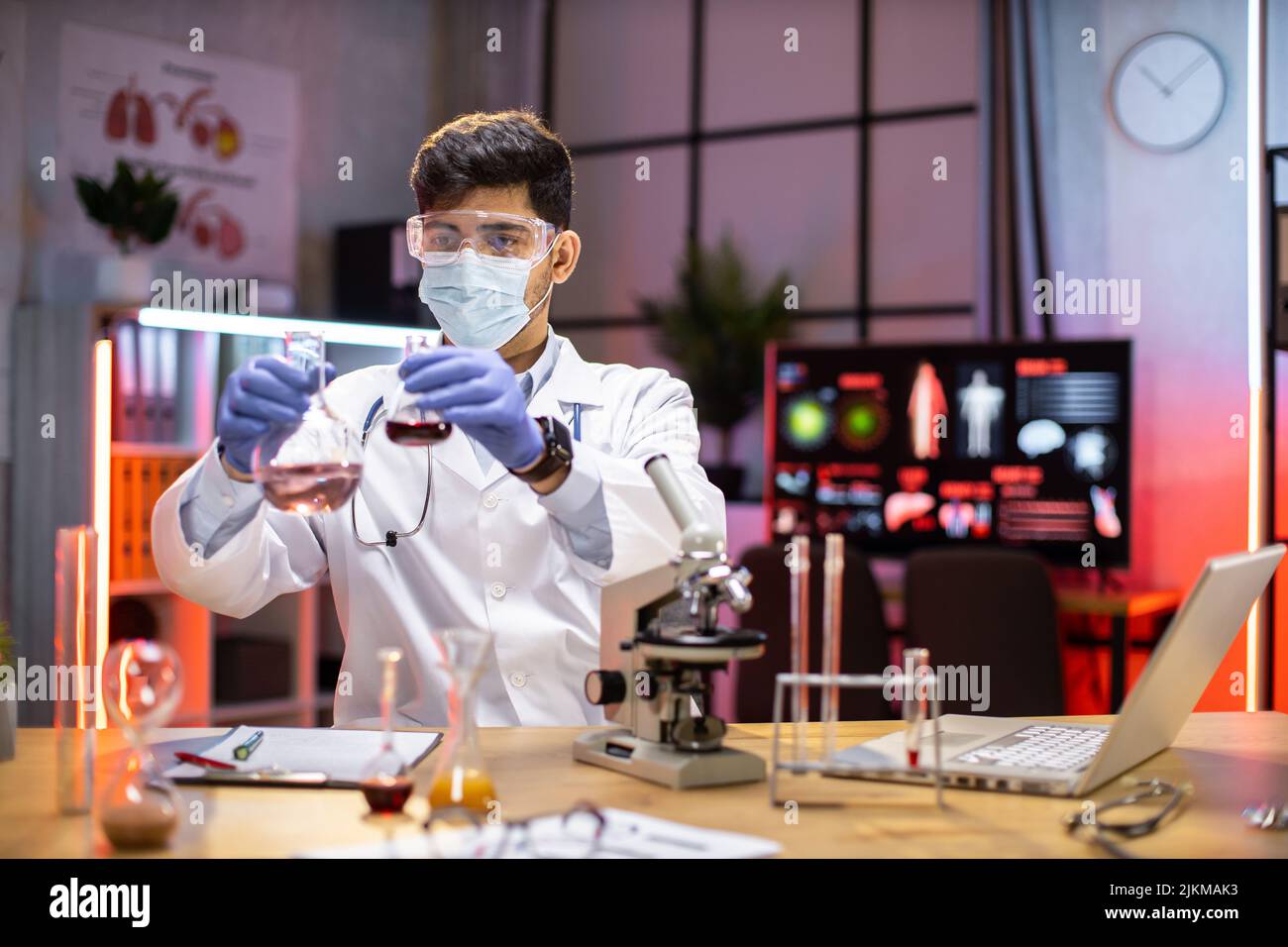 Male scientist testing experiment in a science lab where he holding ...