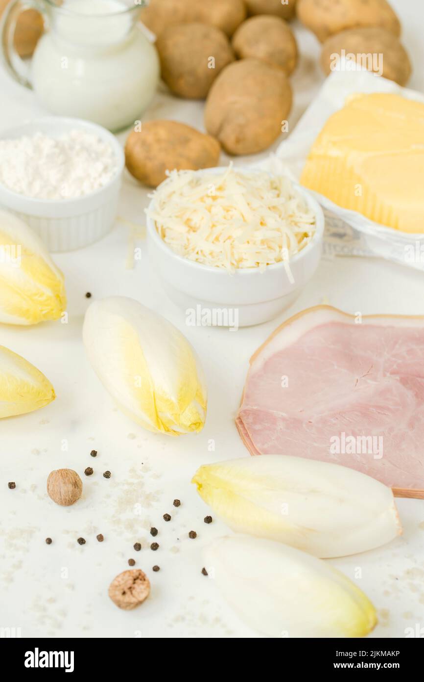 A vertical shot of ingredients of a Belgian classic dish called Chicon ...