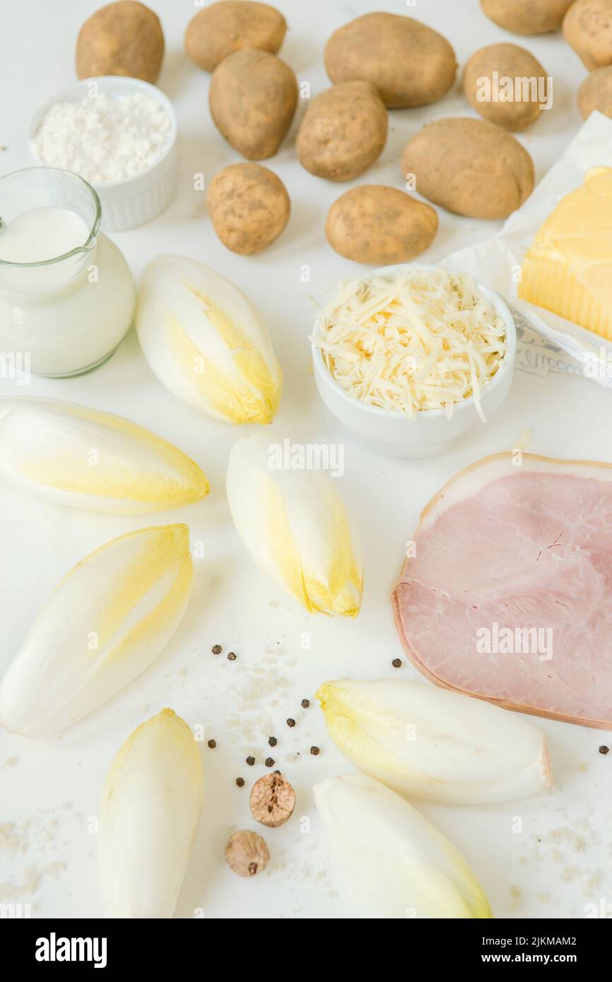 A vertical shot of ingredients of a Belgian classic dish called Chicon ...