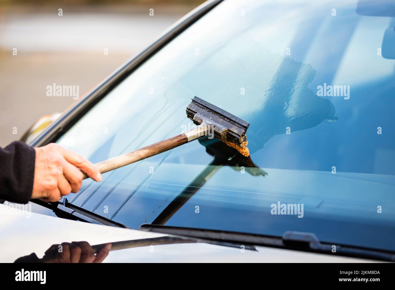 Clean the car window with a puller Stock Photo - Alamy