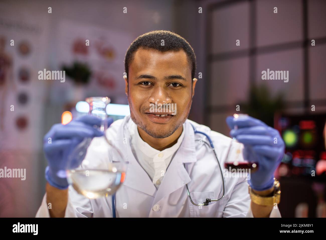 Yong african male scientist working with test tubes wearing lab coat ...