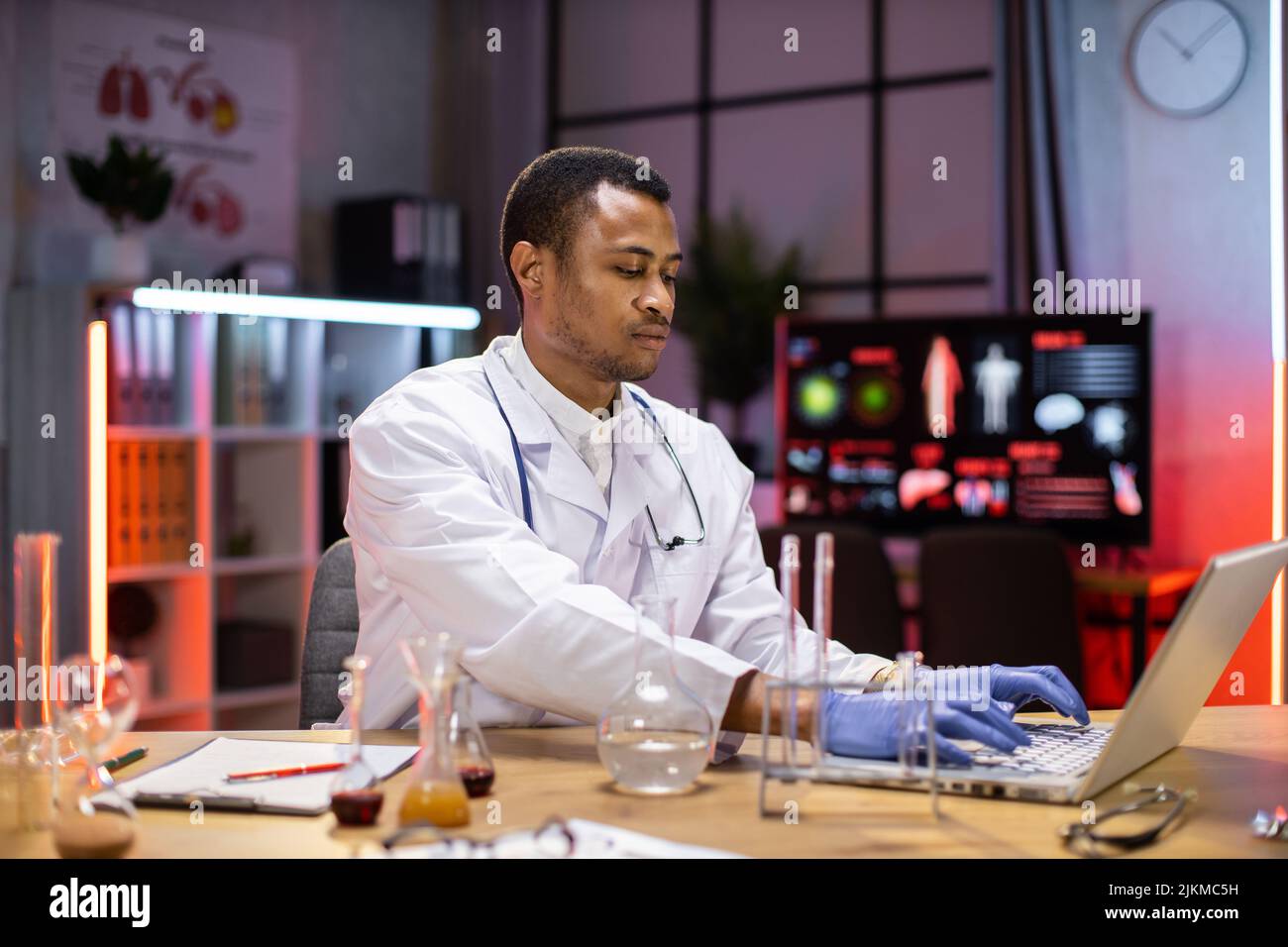 Male african american scientist testing experiment in science lab using ...