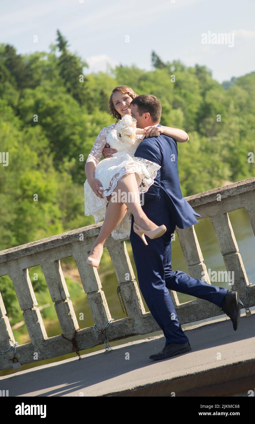 A vertical shot of the couple- the groom carrying the bride in his arms ...