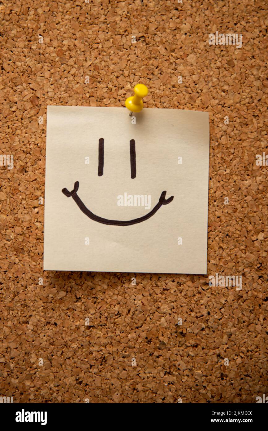 A vertical shot of a smiley face on an attached sticky note Stock Photo ...