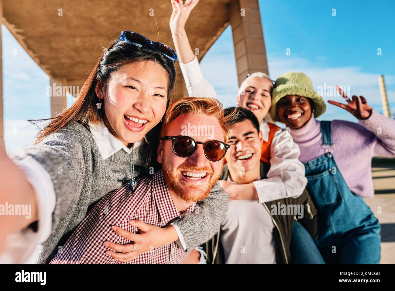 one young couple and three friends at the back having fun making a ...