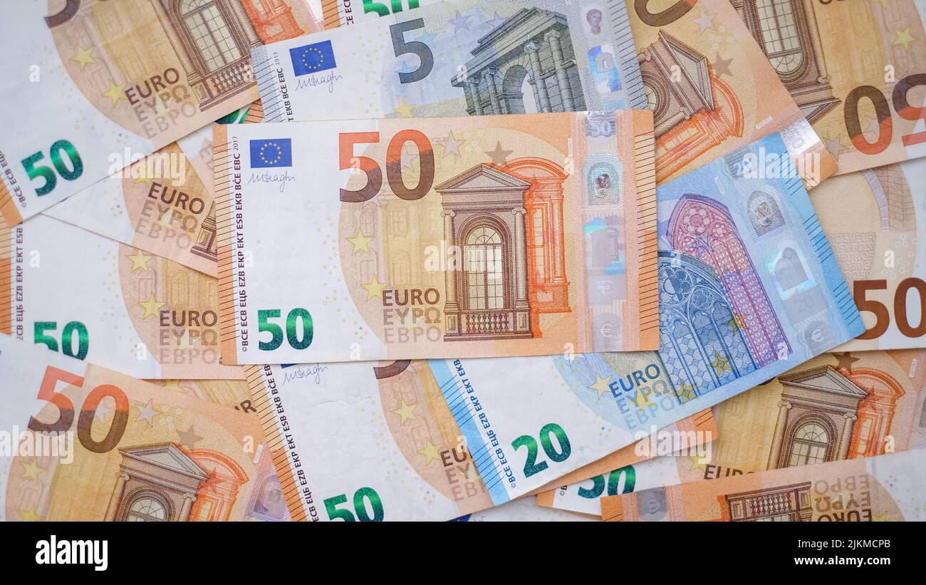 The background consists of many euro banknotes of different ...