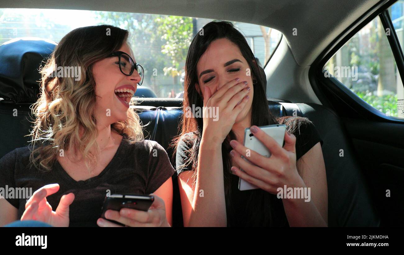 Friends laughing in the back seat of a taxi cab Stock Photo - Alamy