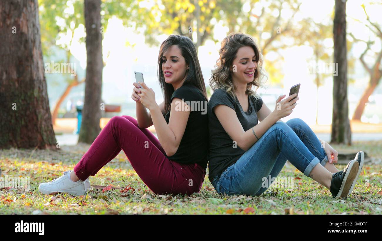 Friends together sharing internet media content together outdoors ...